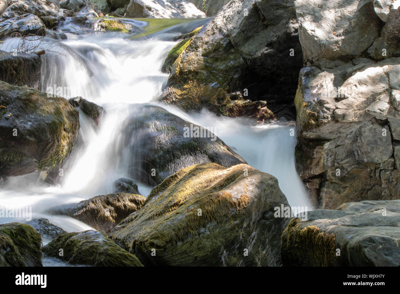 Clean water flowing between cliffs Stock Photo - Alamy