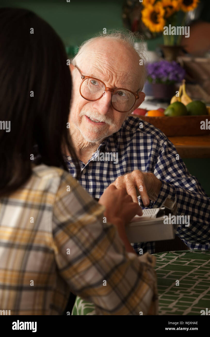 Elderly man in home with care provider or survey taker in kitchen Stock ...