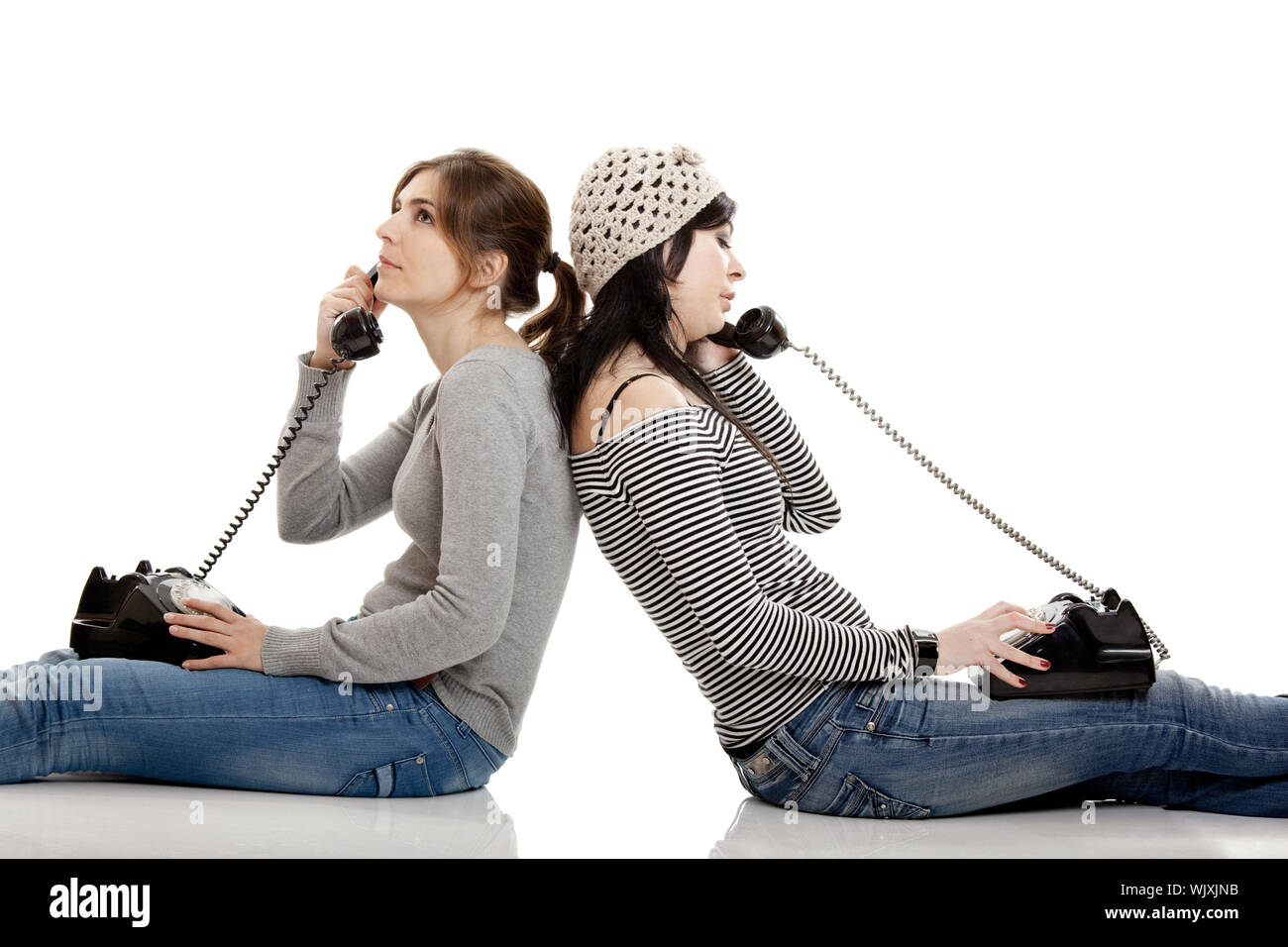 Two young women talking with old telephones - Isolated on white Stock ...