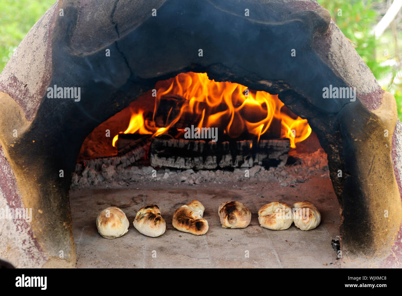 Stone wood oven with fire baking fresh homemade bread Stock Photo - Alamy