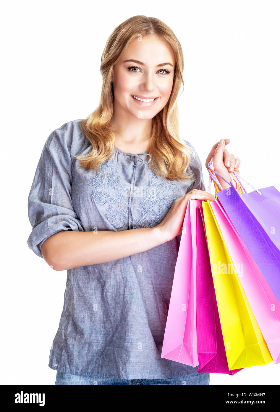 Happy shopper girl with four colourful paper bags isolated on white ...
