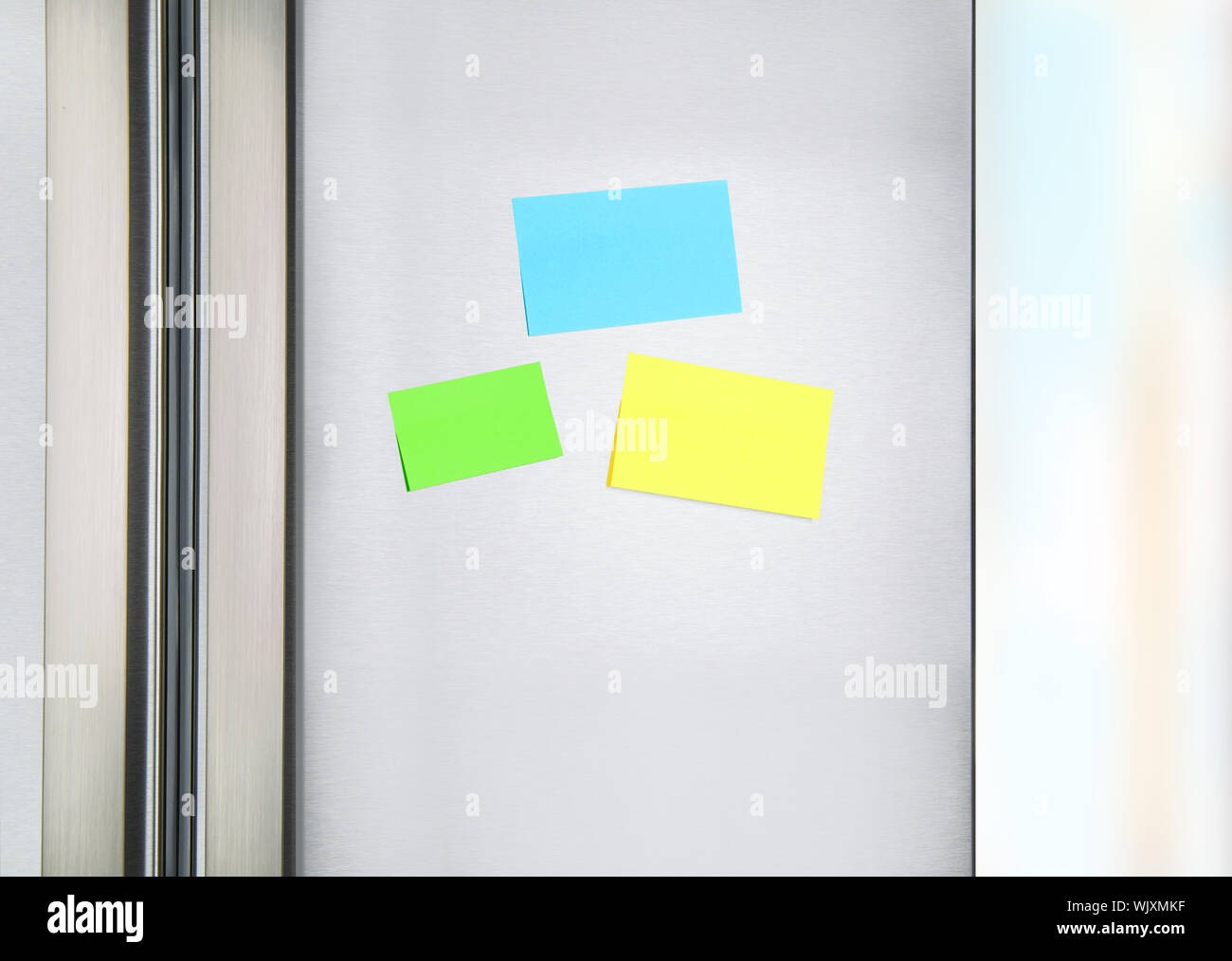 Sticky notes on the fridge, three colorful paper on the door on ...