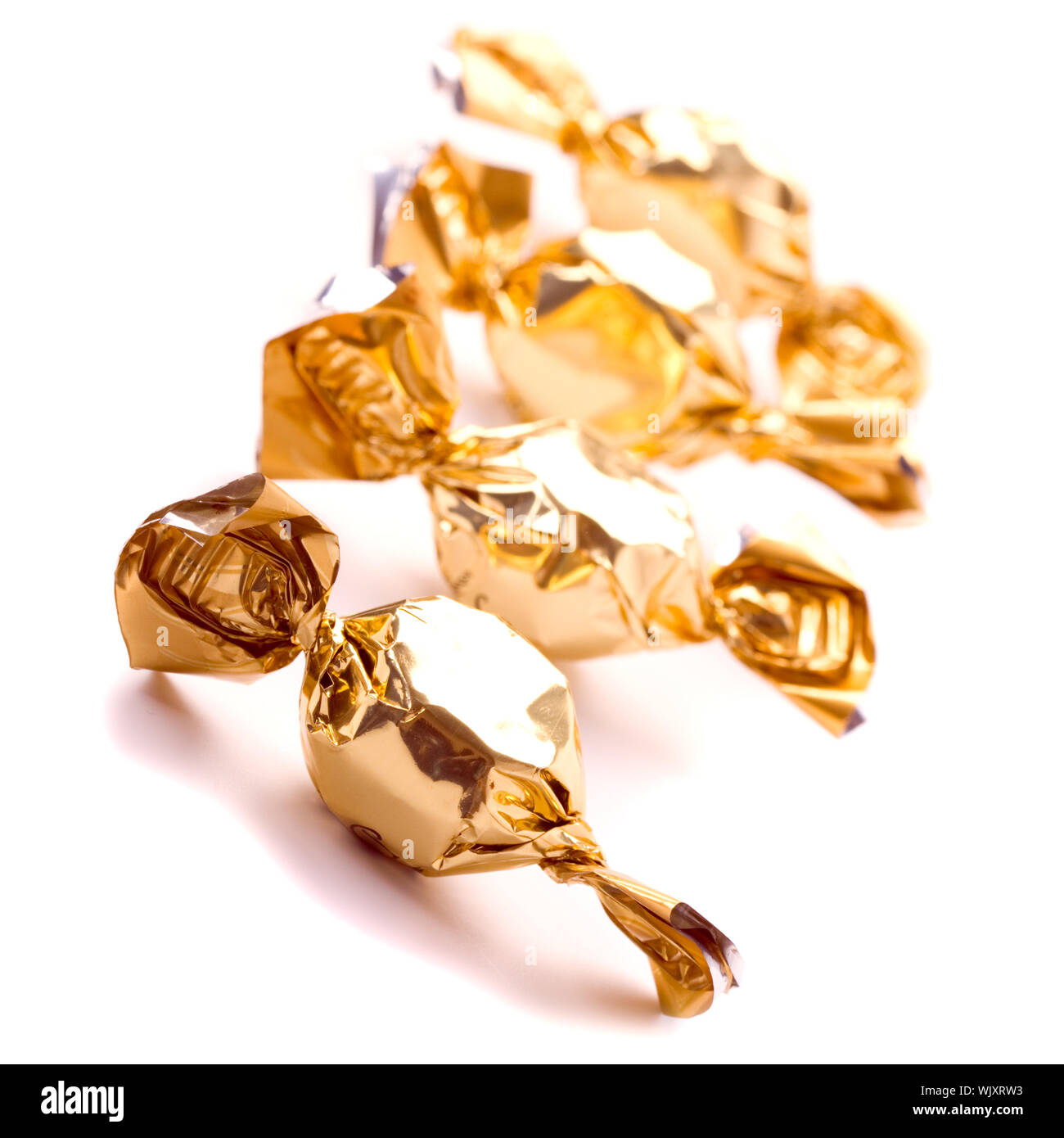golden sweets closeup on white background Stock Photo - Alamy