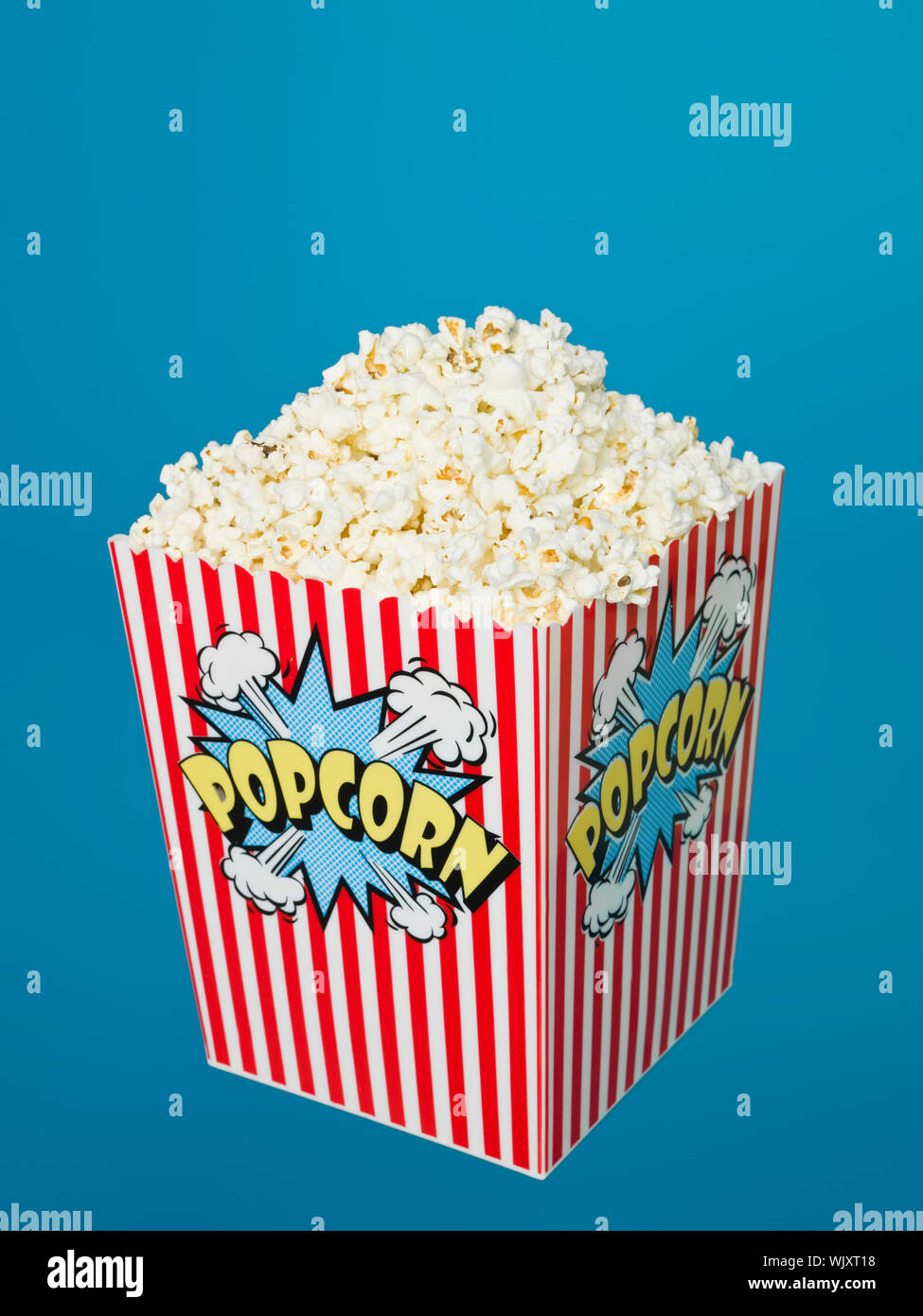 Basket of Popcorn on blue background Stock Photo - Alamy