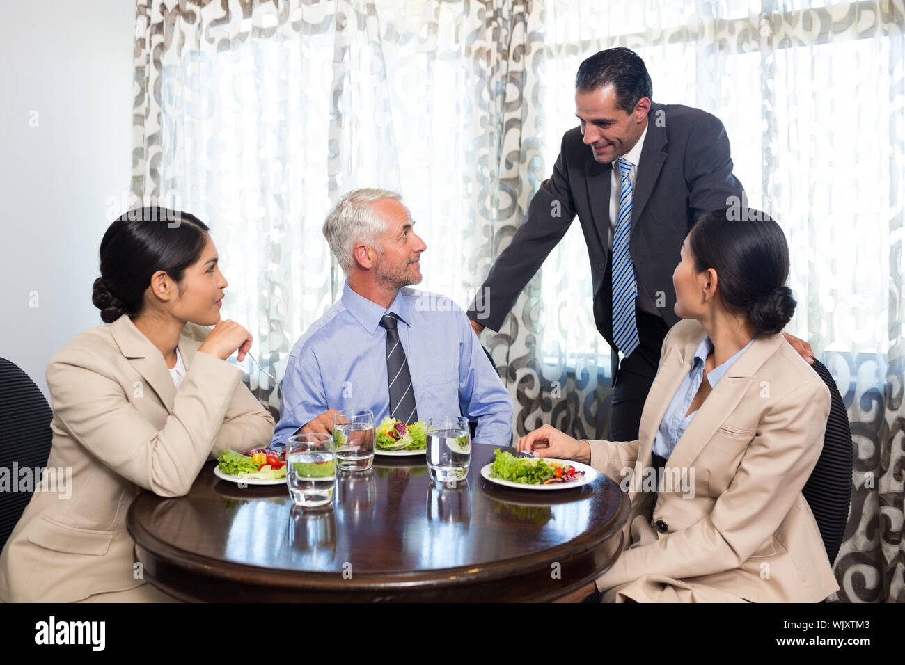 Business colleagues having meal together around the table Stock Photo ...