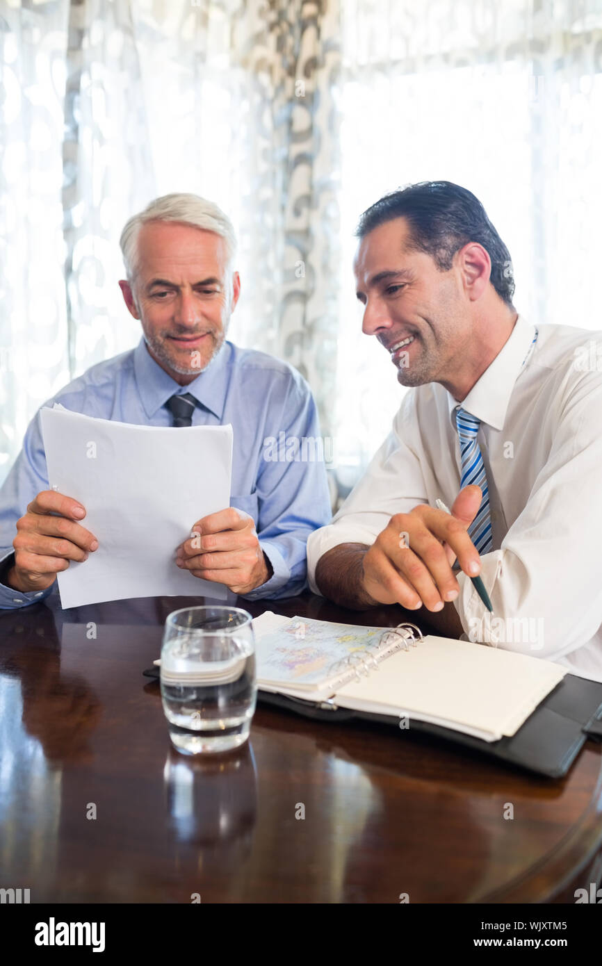 Two businessmen doing paperwork at desk in the office Stock Photo - Alamy