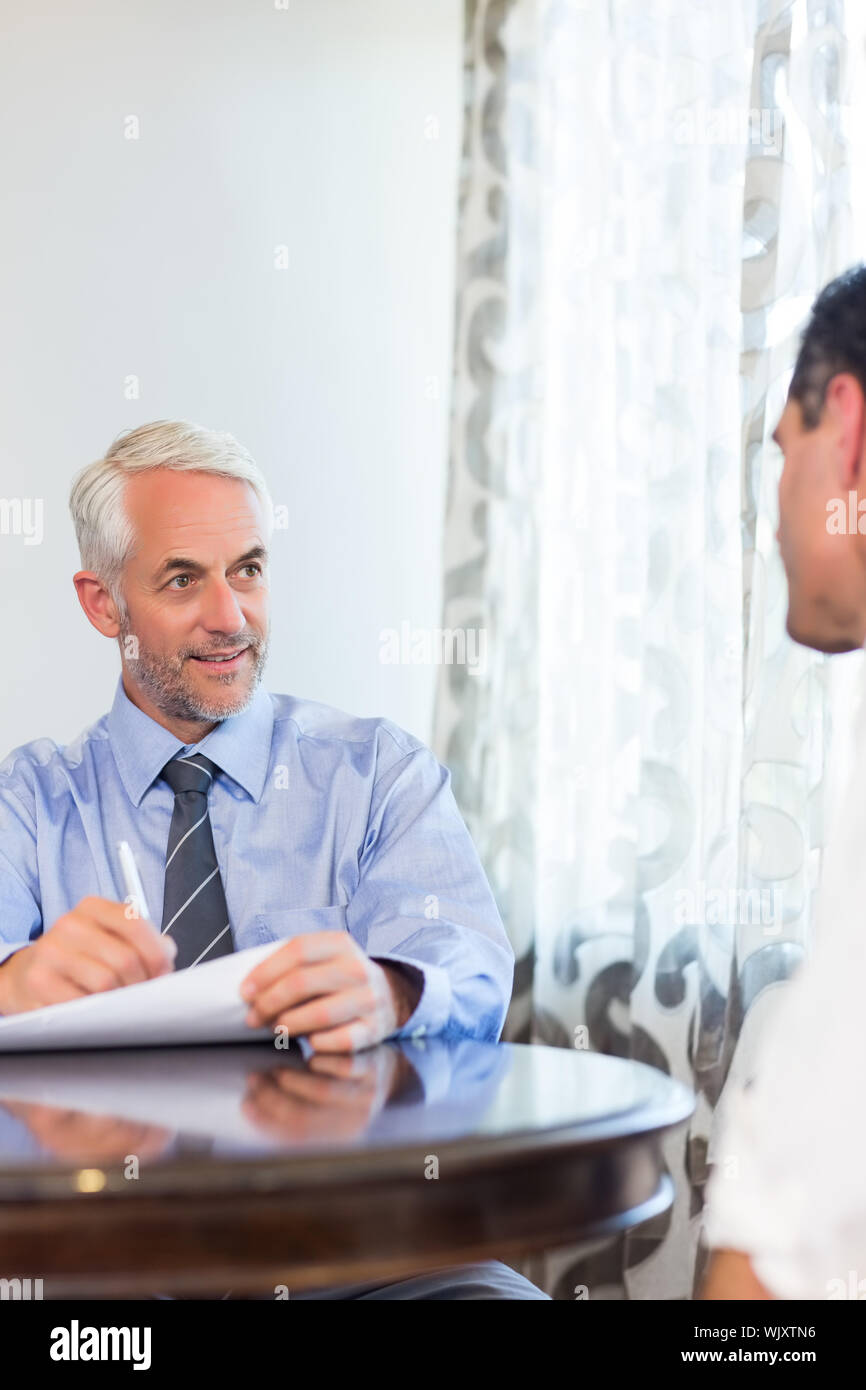 Two businessmen doing paperwork at desk in the office Stock Photo - Alamy