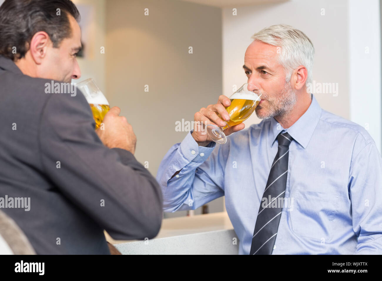 Two business colleagues drinking beer at the bar counter Stock Photo ...