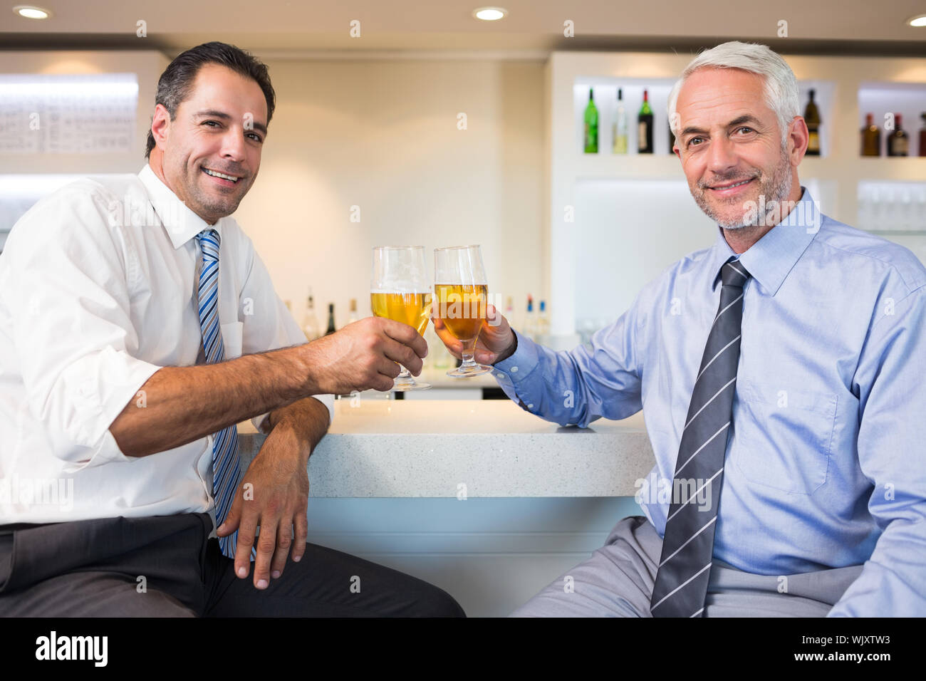 Two business colleagues toasting beer glasses at the bar counter Stock ...