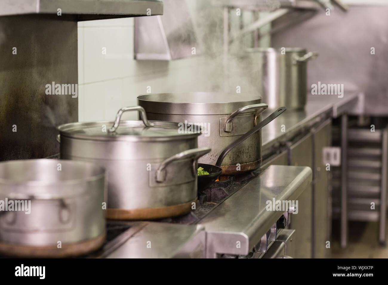 Large steaming pots on the stove in a commercial kitchen Stock Photo ...