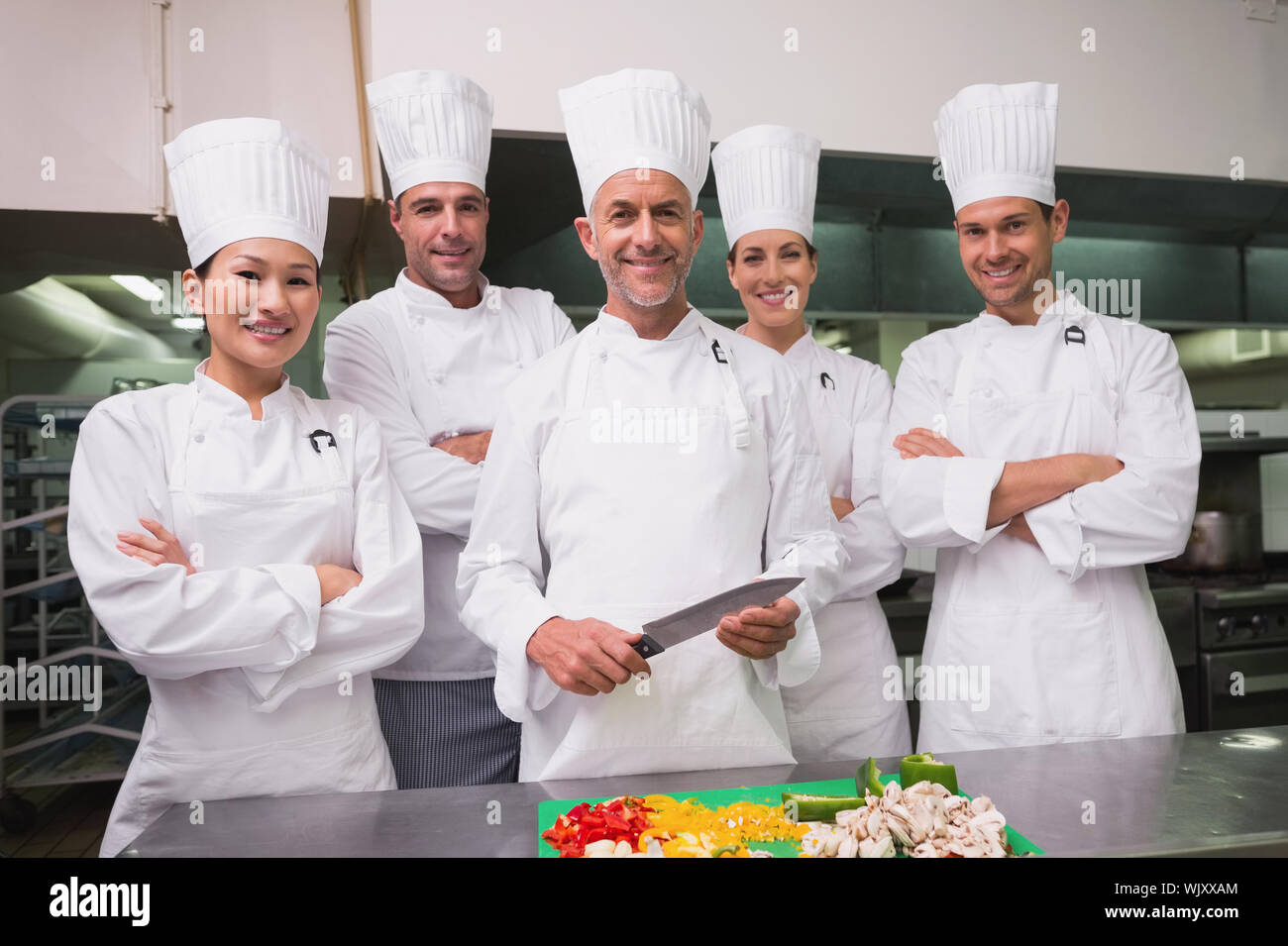 Head chef standing with happy trainees in a commercial kitchen Stock ...