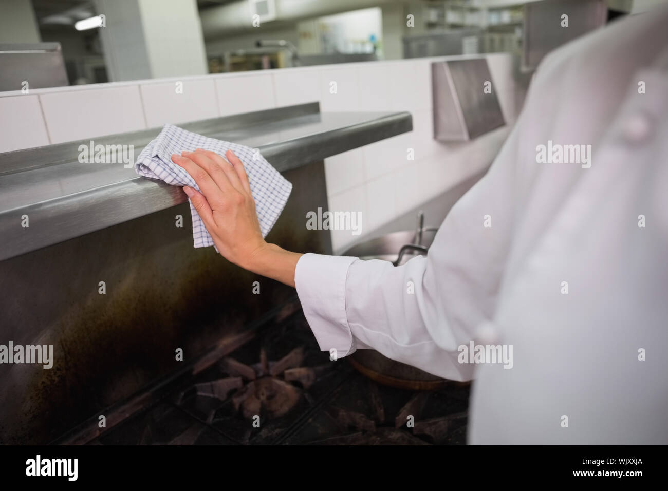 Chef wiping down surface in a commercial kitchen Stock Photo - Alamy