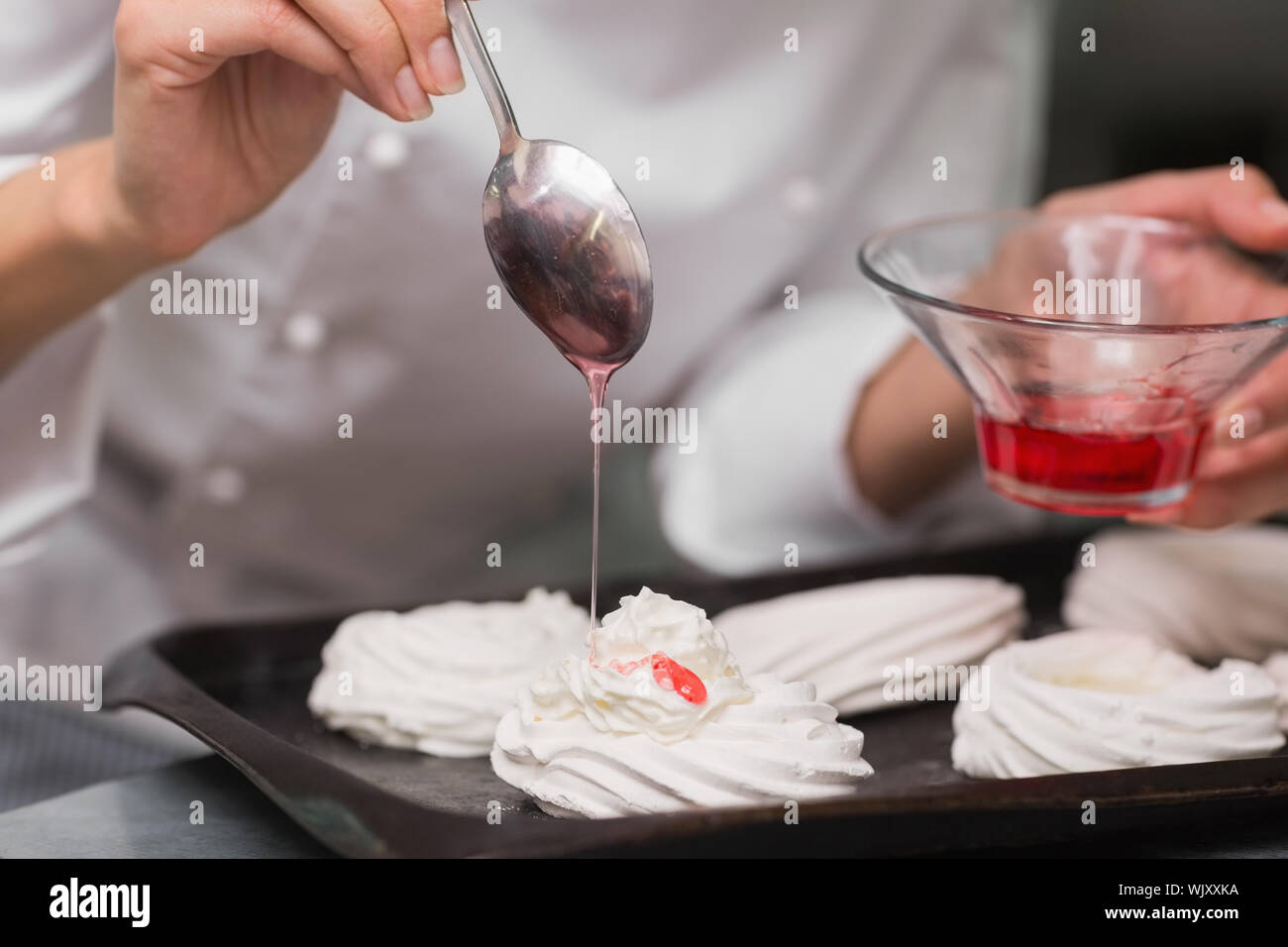 Chef pouring syrup over meringues in a commercial kitchen Stock Photo ...
