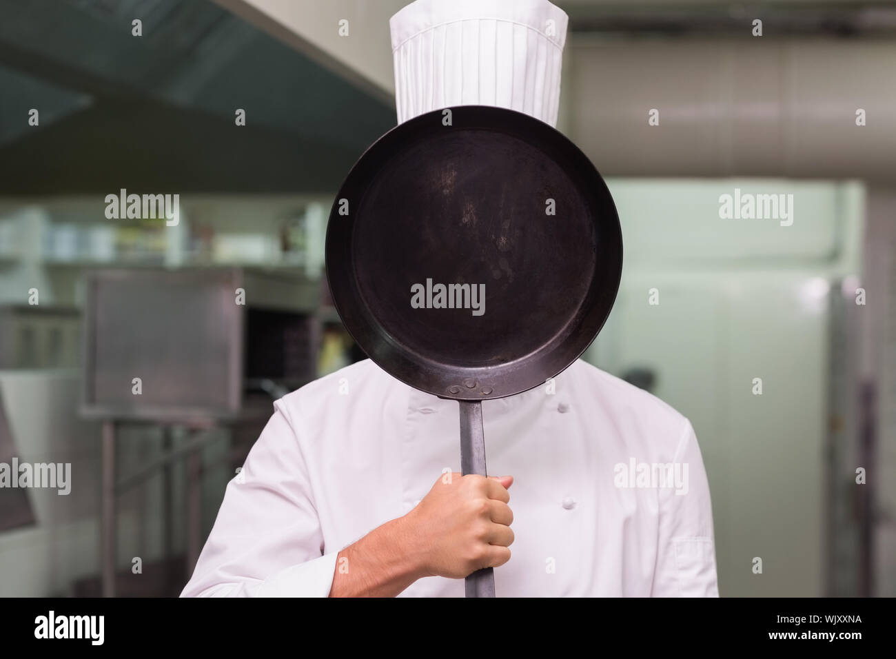 Chef covering face with pan in a commercial kitchen Stock Photo - Alamy