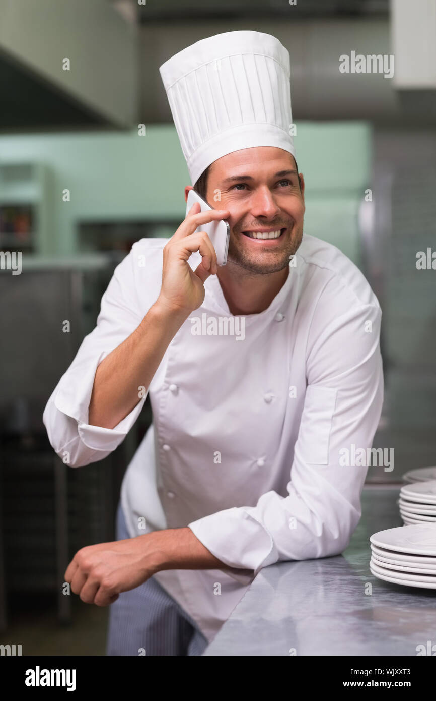 Happy chef talking on the phone in a commercial kitchen Stock Photo - Alamy