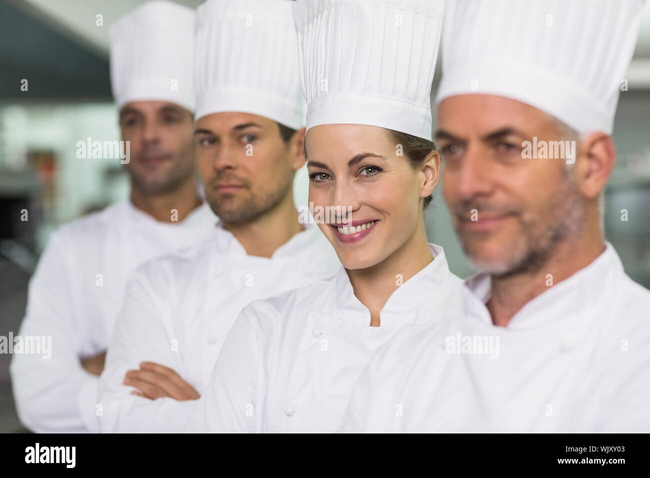 Happy team of chefs standing in line in a commercial kitchen Stock ...