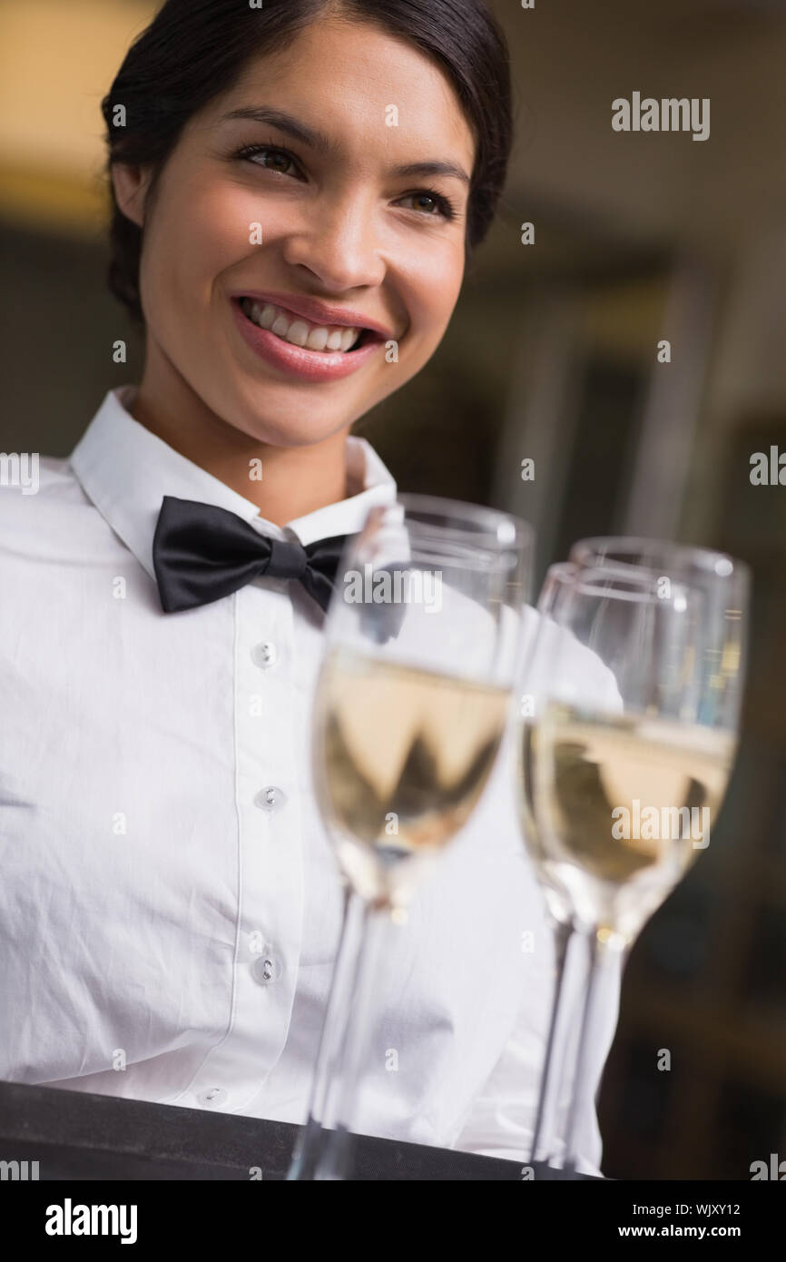 Pretty waitress holding a tray of champagne in a fancy restaurant Stock ...