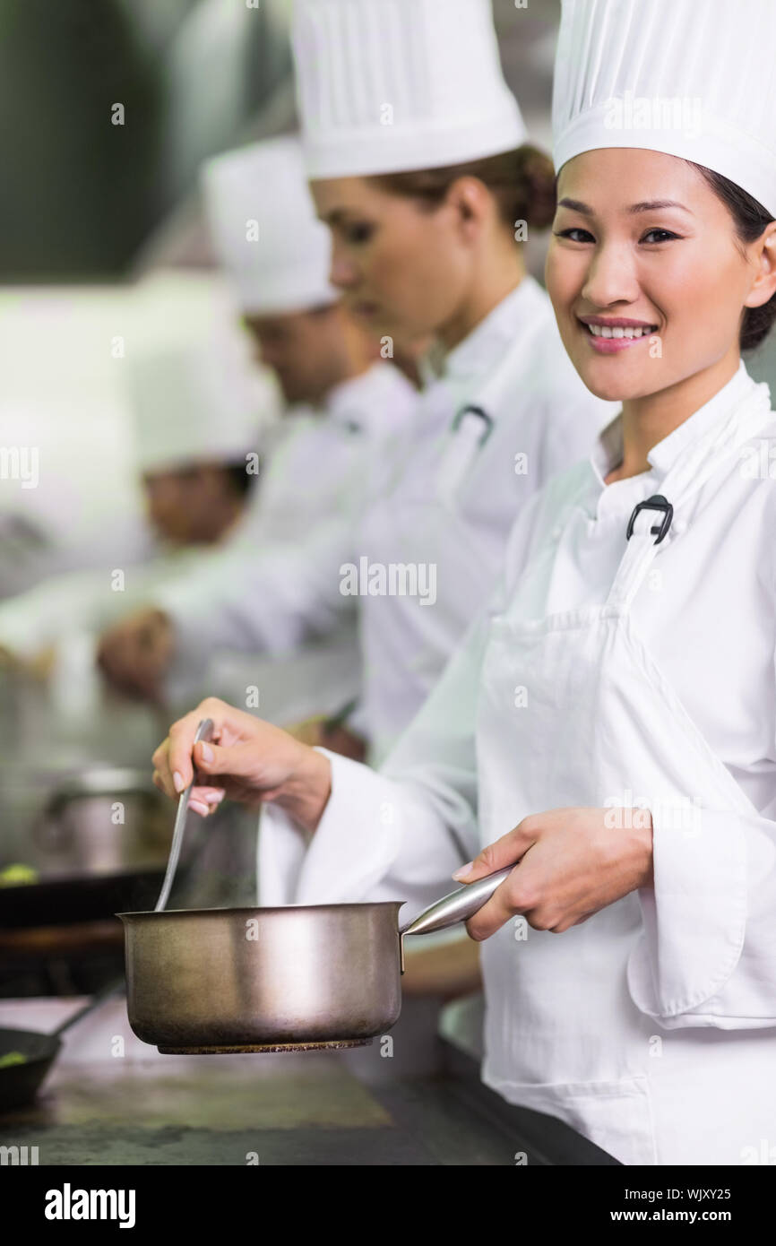 Happy chef cooking at stove in a commercial kitchen Stock Photo - Alamy