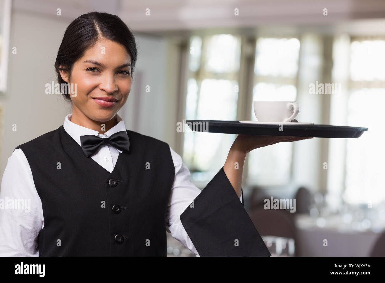Pretty waitress holding a tray with a cup in a fancy restaurant Stock ...