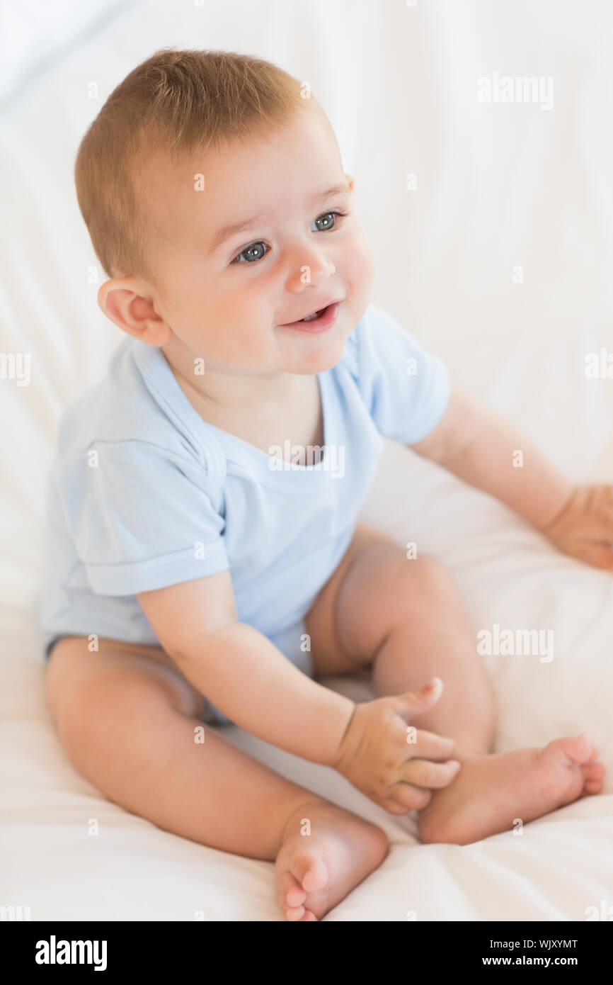 Baby boy in blue babygro at home in bedroom Stock Photo - Alamy