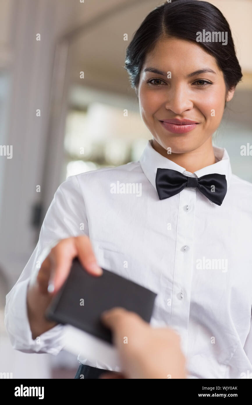 Happy waitress holding the bill in a fancy restaurant Stock Photo - Alamy