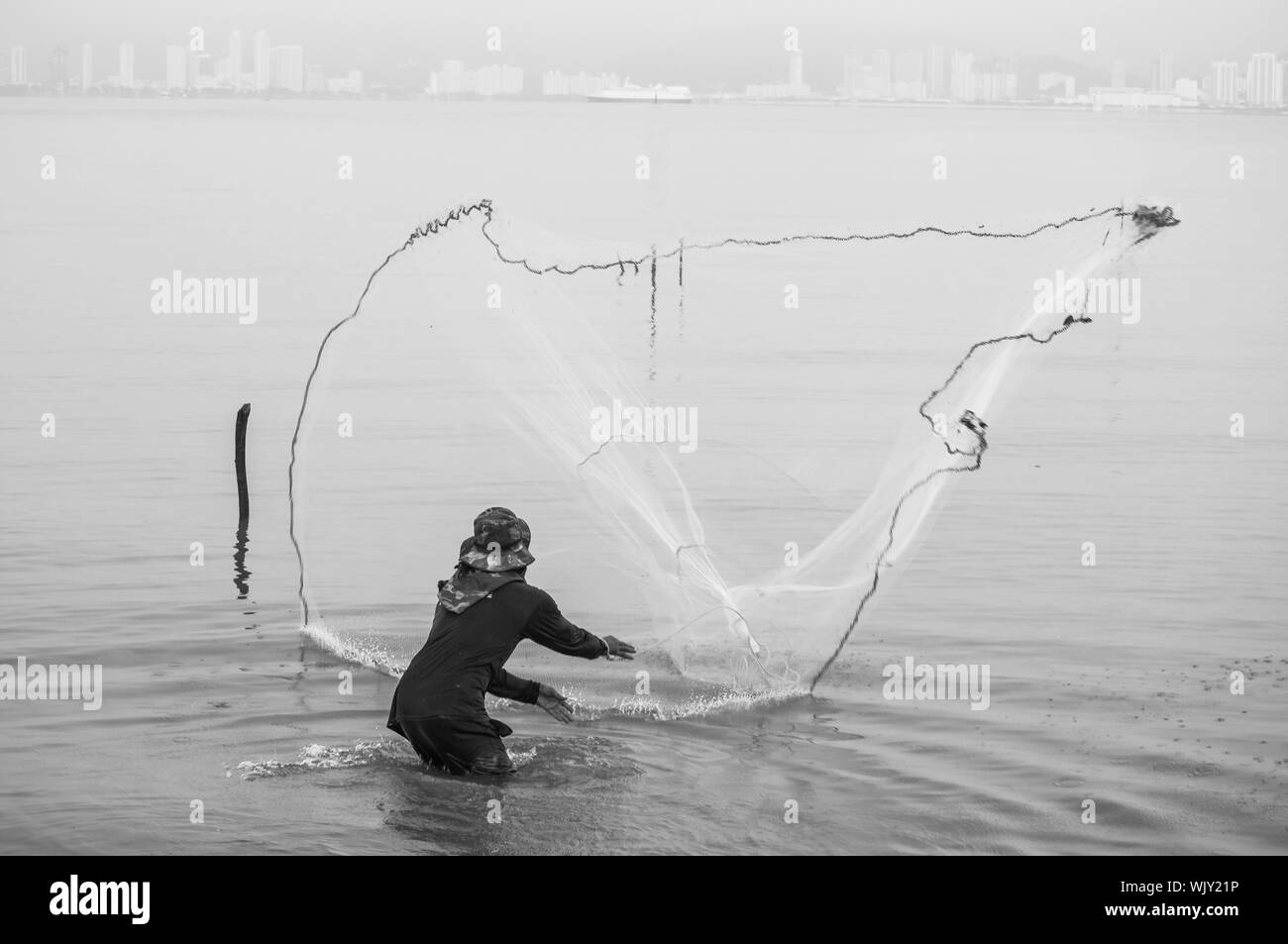 Man Throwing Fishing Net Into Water Stock Photos & Man Throwing Fishing ...