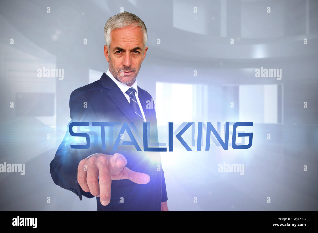 The word stalking and businessman pointing against bright white room ...