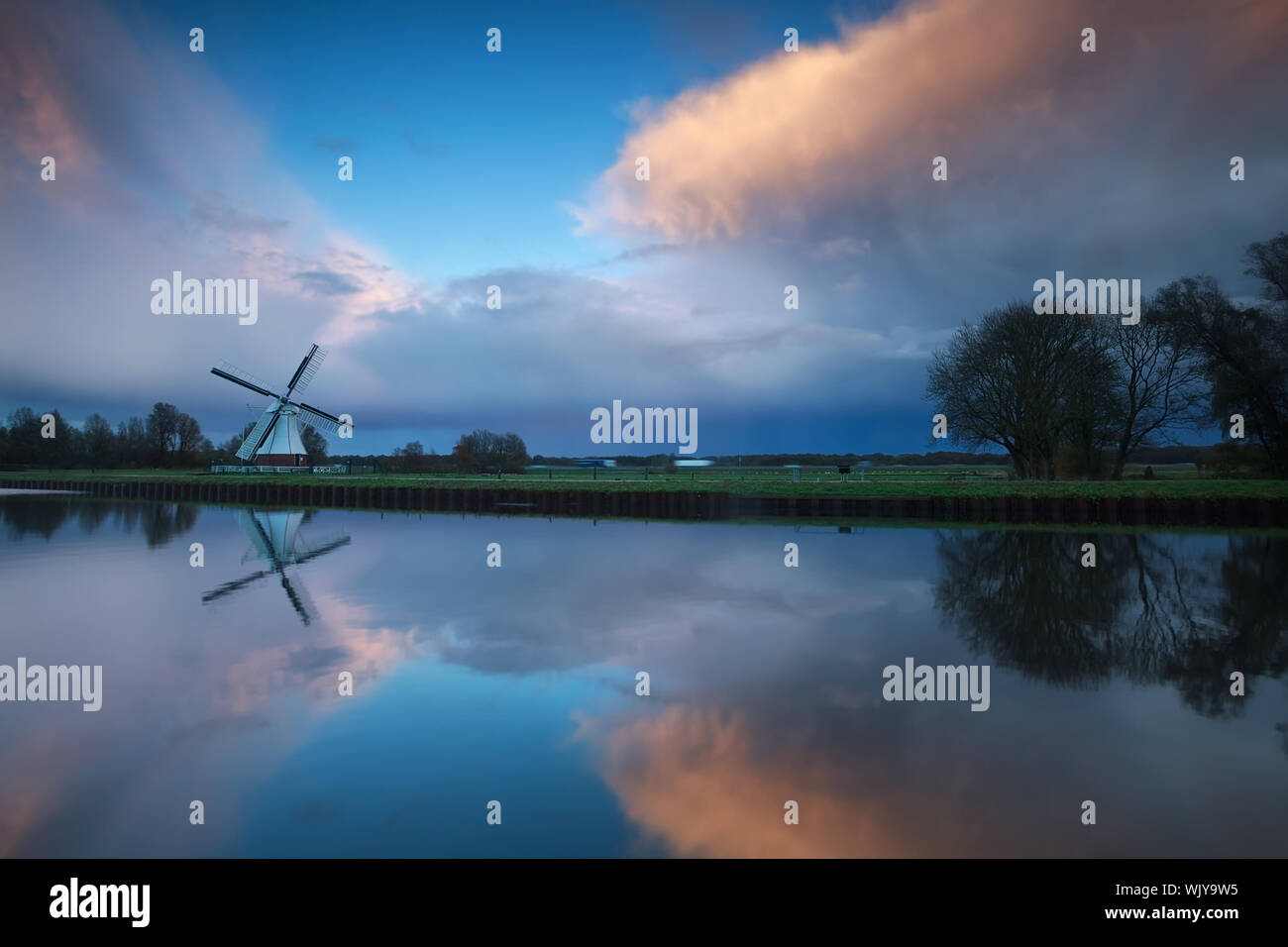 Dutch windmill at stormy sunset, Holland Stock Photo - Alamy