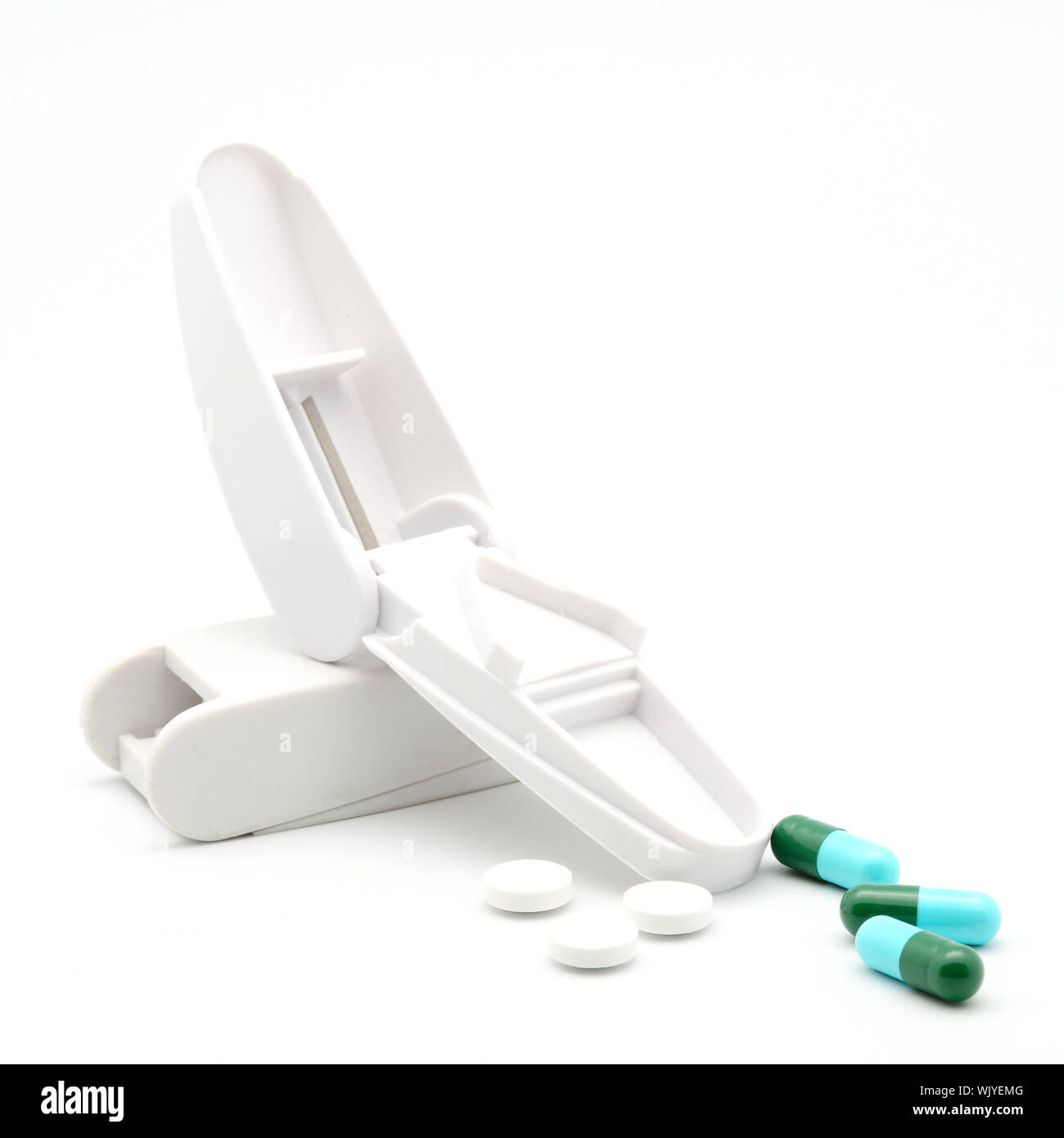 White tablet cutter with capsules and pellets Stock Photo - Alamy
