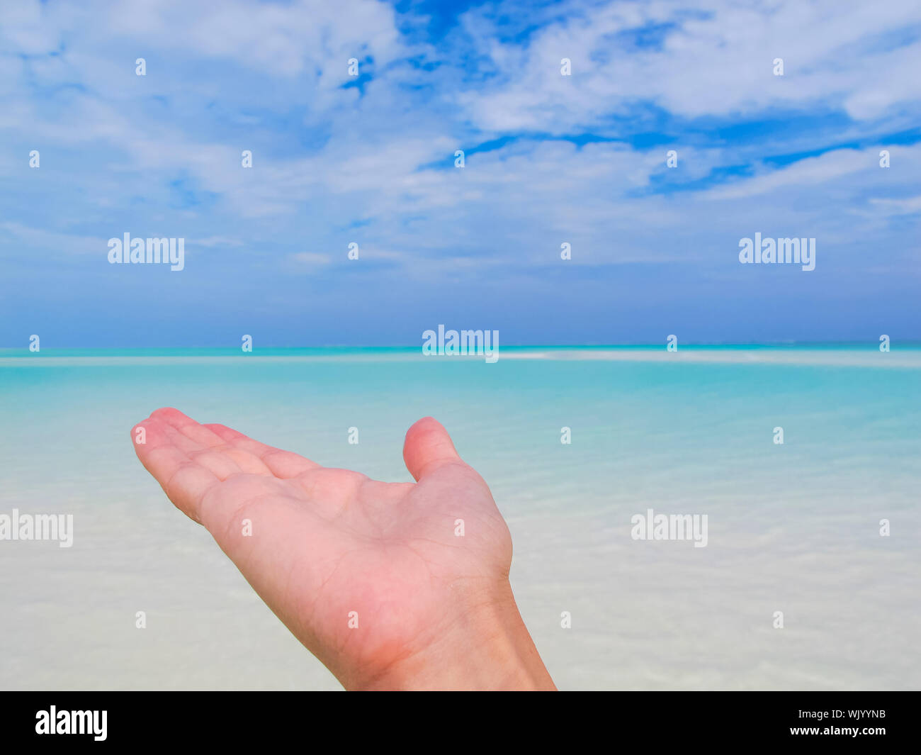Showing hand, beach at the background Stock Photo - Alamy
