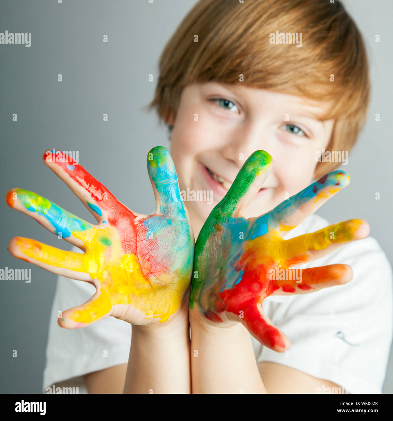 Smiling child showing his colored hands Stock Photo - Alamy