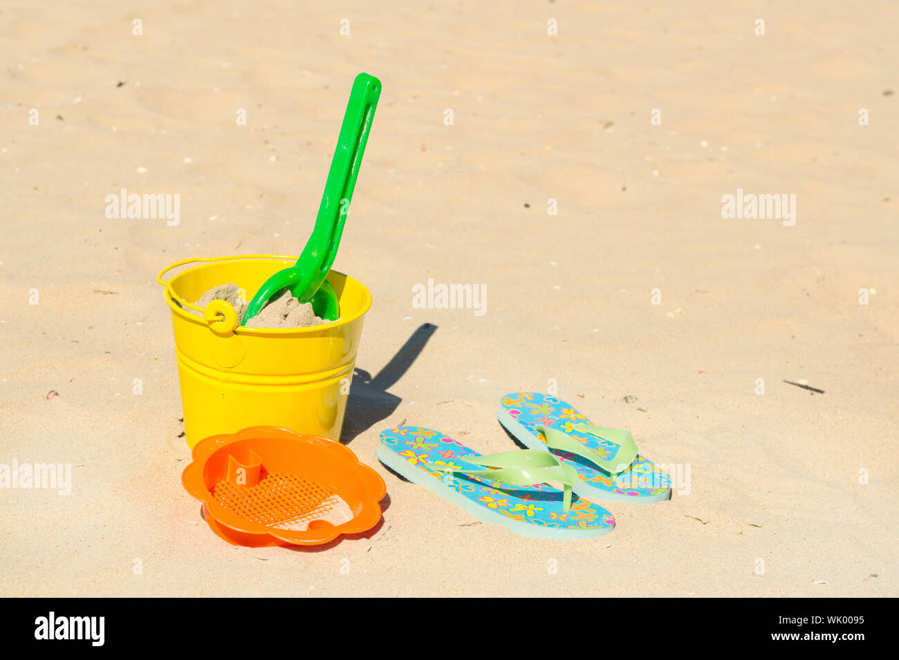 Yellow bucket and other toys at the beach Stock Photo - Alamy