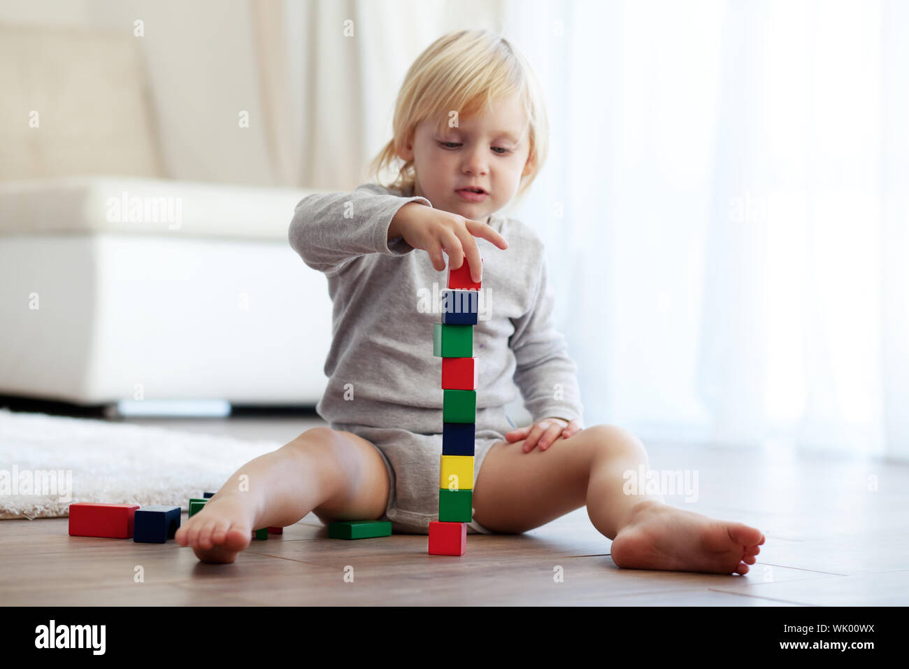 Toddler playing with wooden blocks at home Stock Photo - Alamy