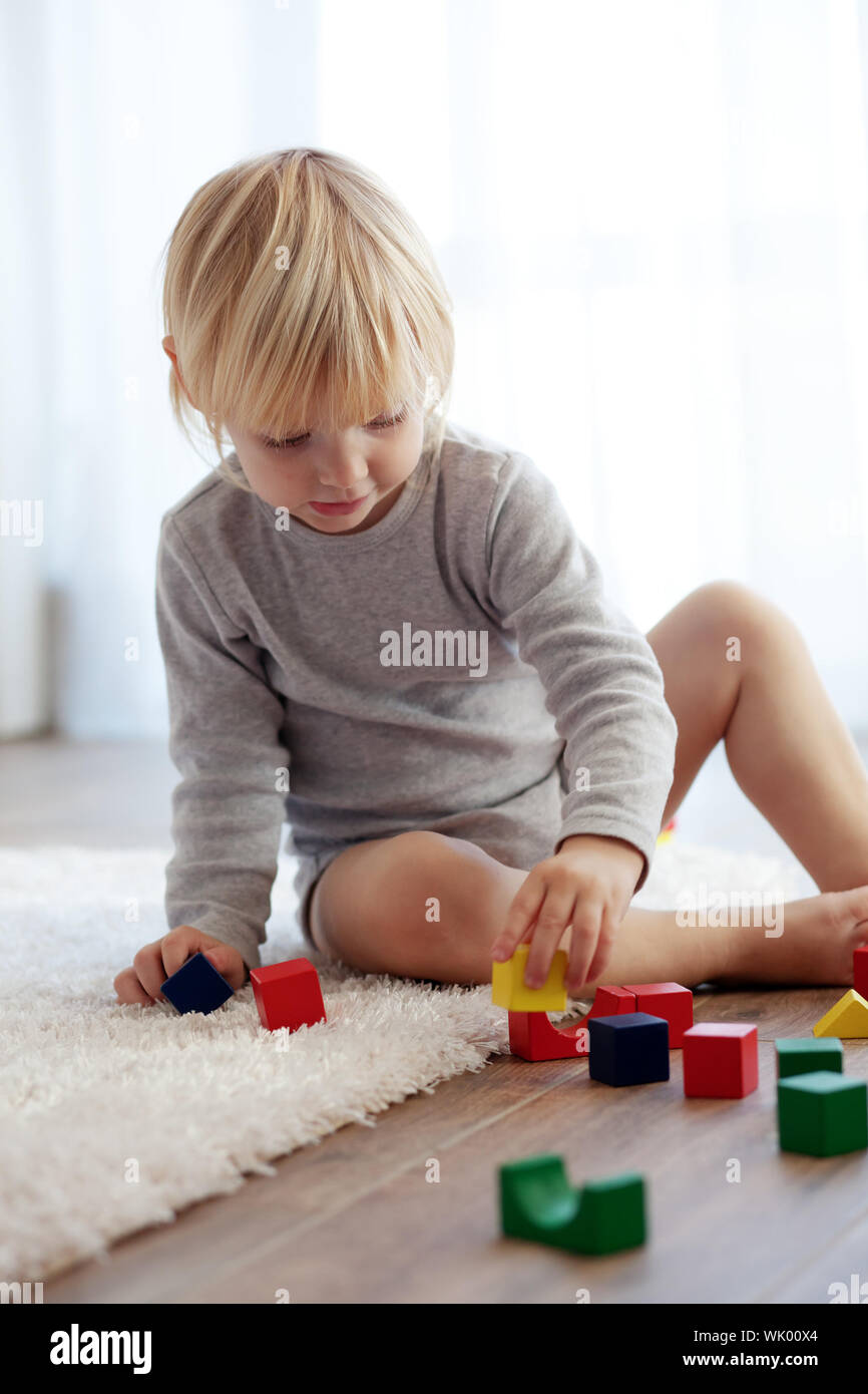 Toddler playing with wooden blocks Stock Photo - Alamy