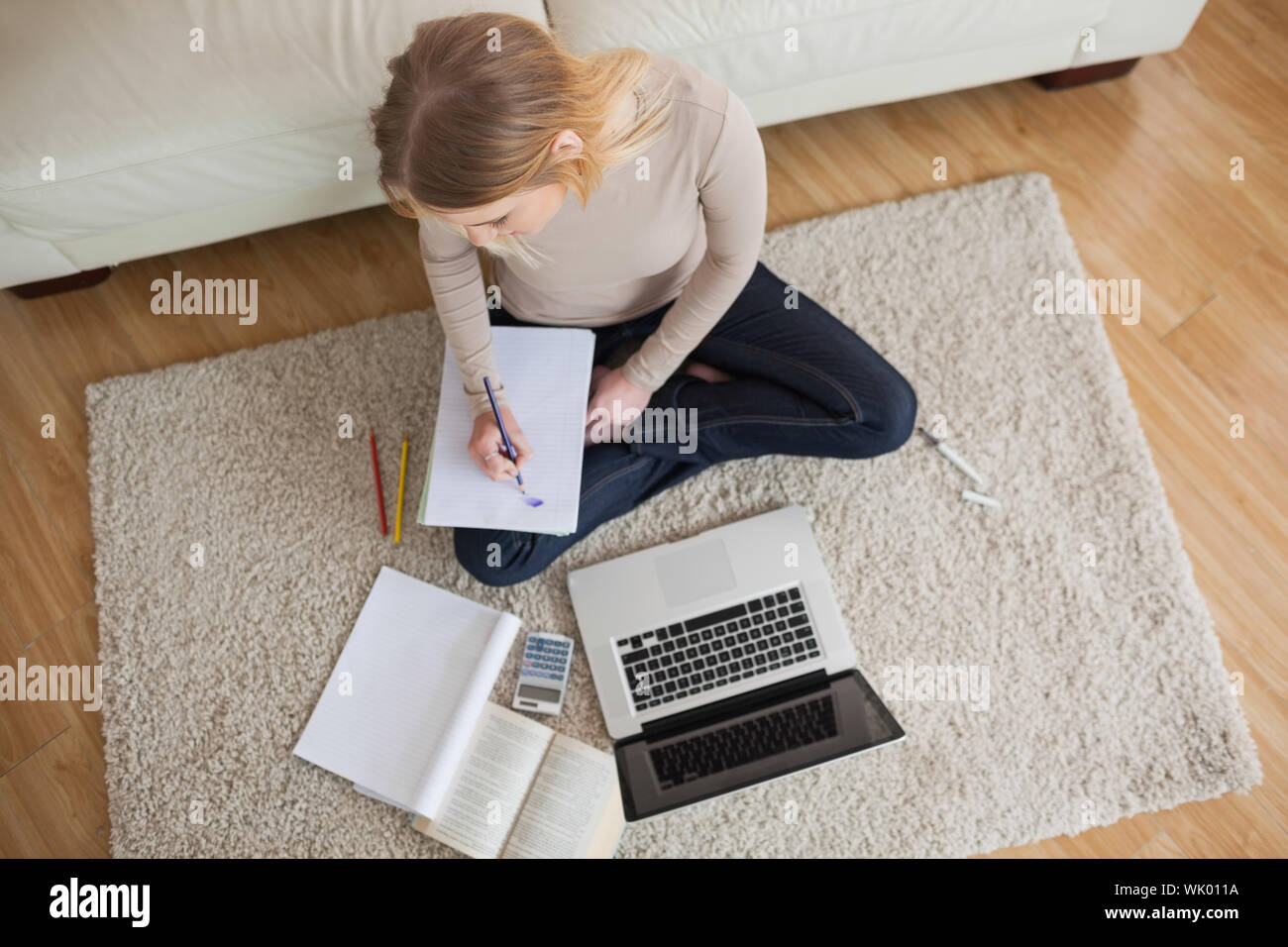 Young woman doing homework and sitting on floor using laptop Stock ...
