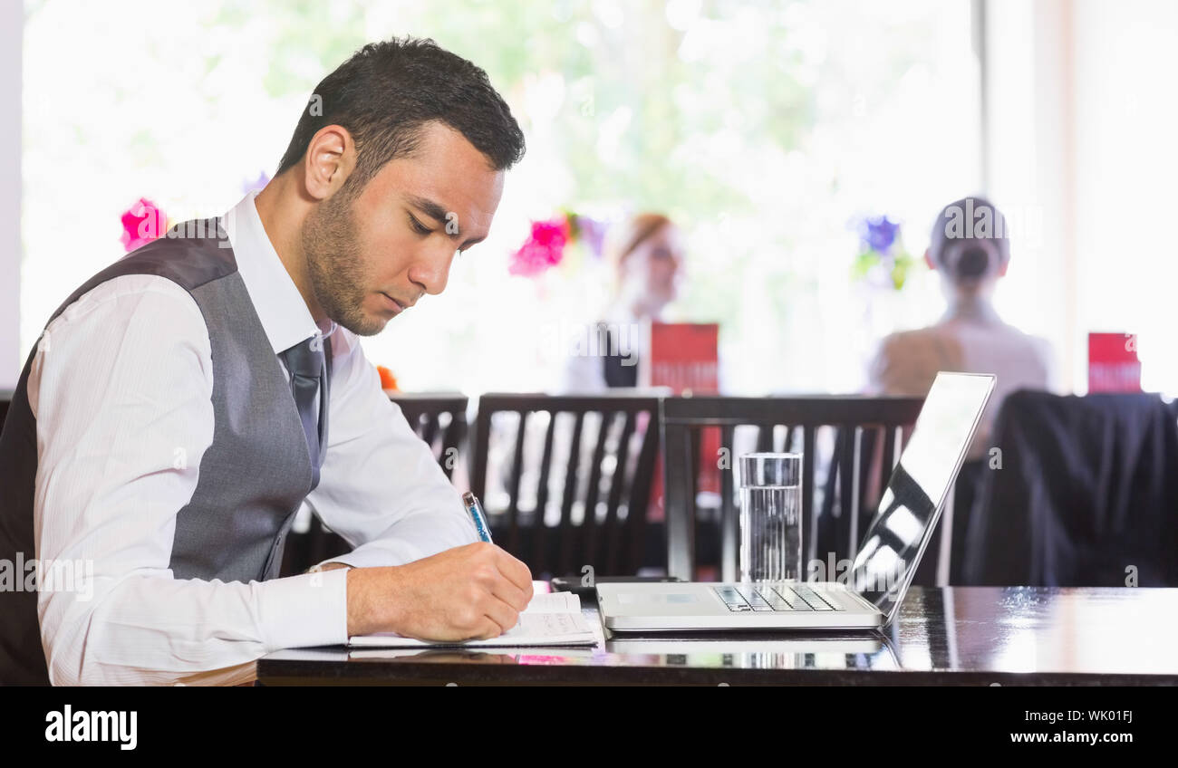 Concentrated businessman writing something Stock Photo - Alamy