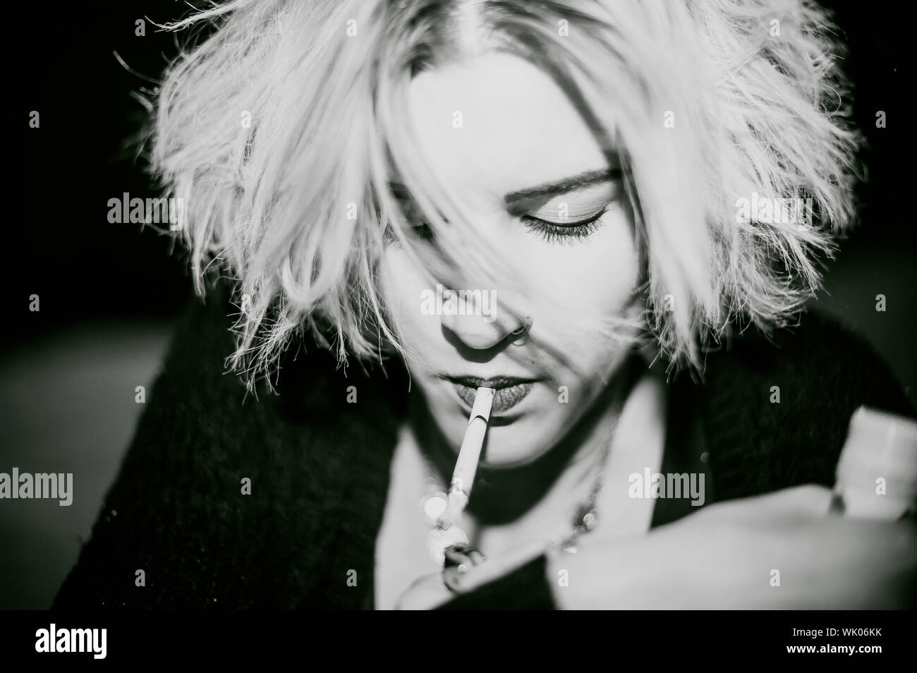 Woman lighting cigarette hi-res stock photography and images - Alamy