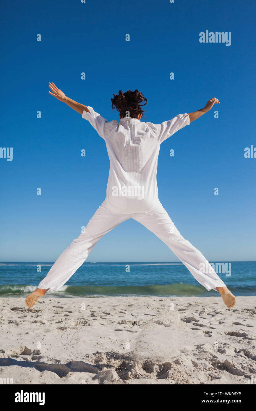 Woman jumping back to camera Stock Photo - Alamy