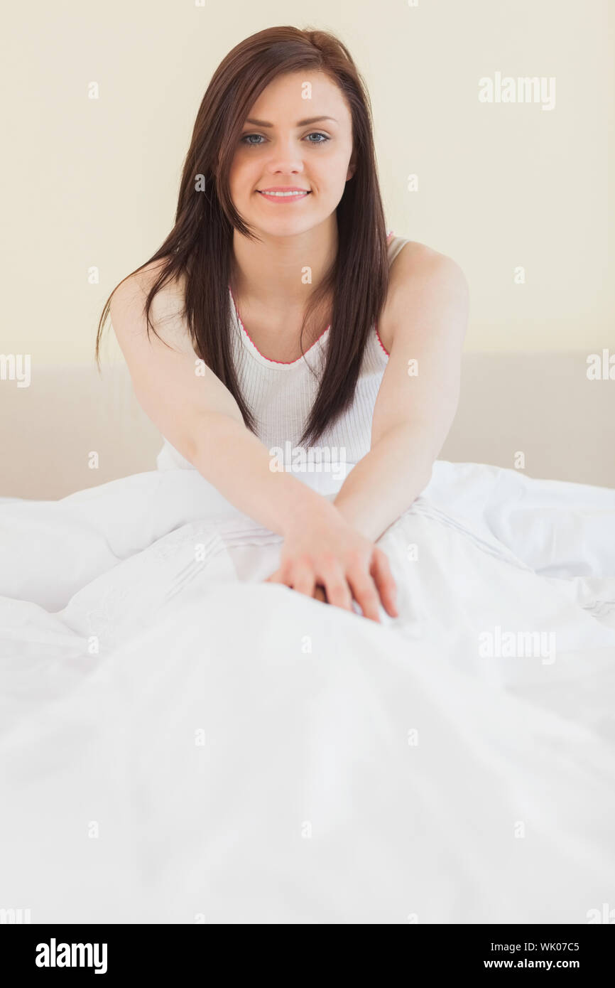 Awakened girl sitting in her bed looking Stock Photo - Alamy