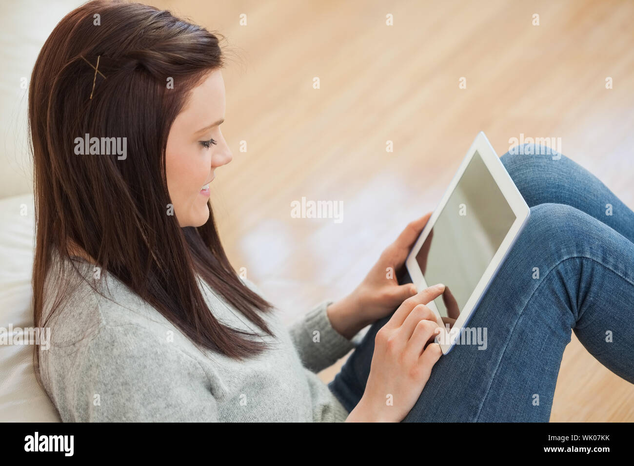 Girl using a tablet sitting on the floor Stock Photo - Alamy