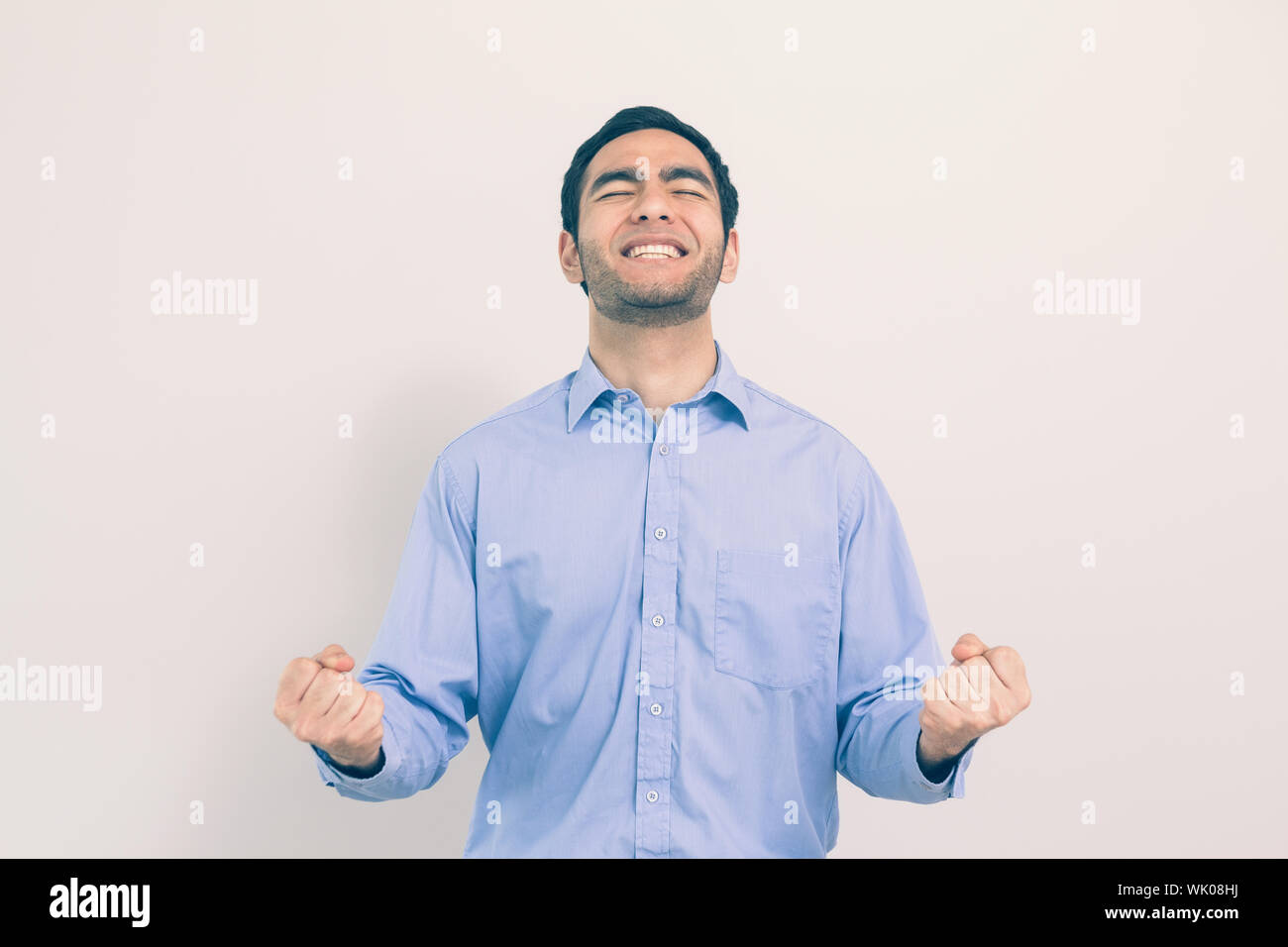 Victorious man standing clenching his fists Stock Photo - Alamy