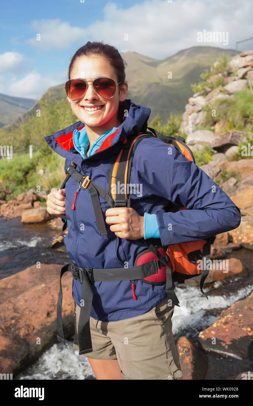 Brunette wearing rain jacket and sunglasses smiling Stock Photo - Alamy