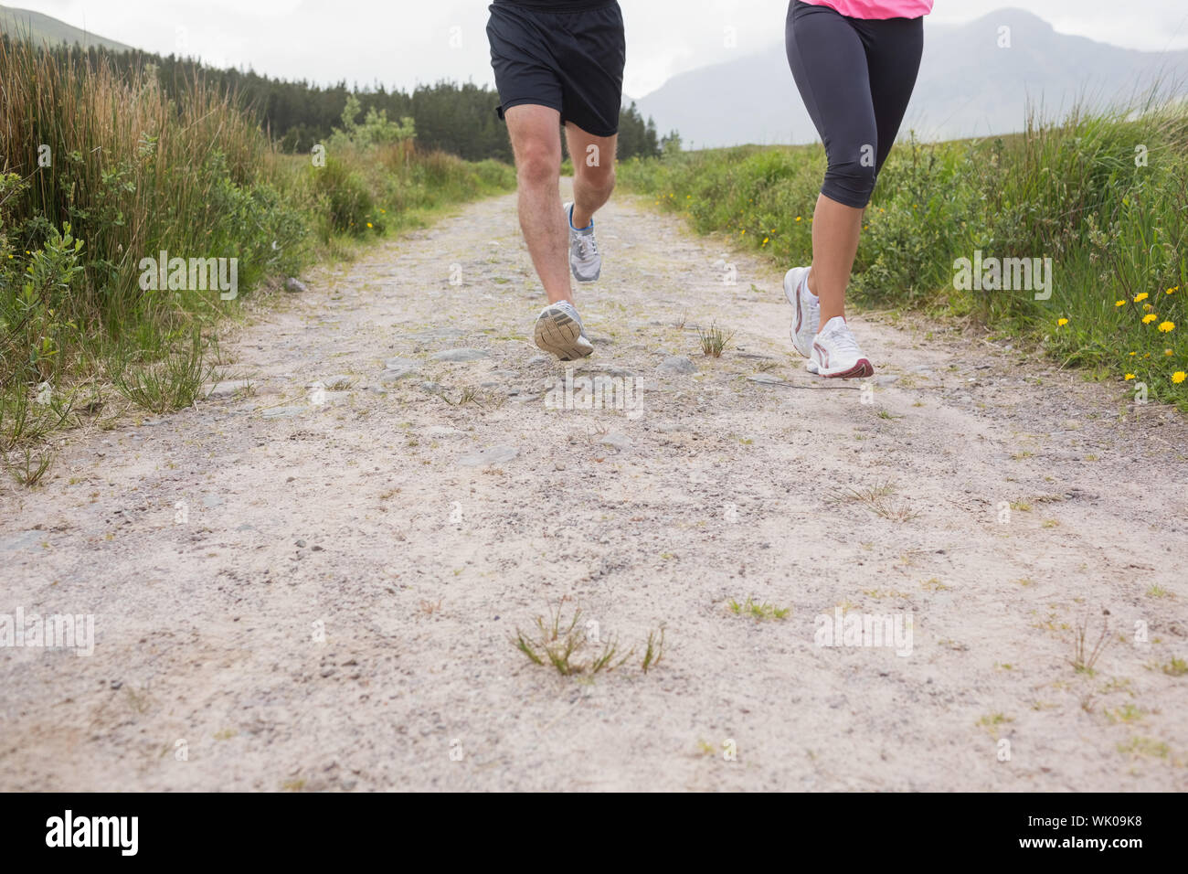 Couples feet running on trail Stock Photo - Alamy