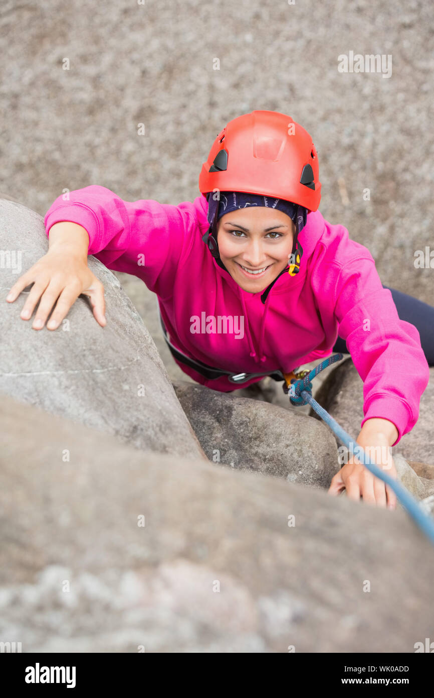 Happy girl climbing up rock face Stock Photo - Alamy