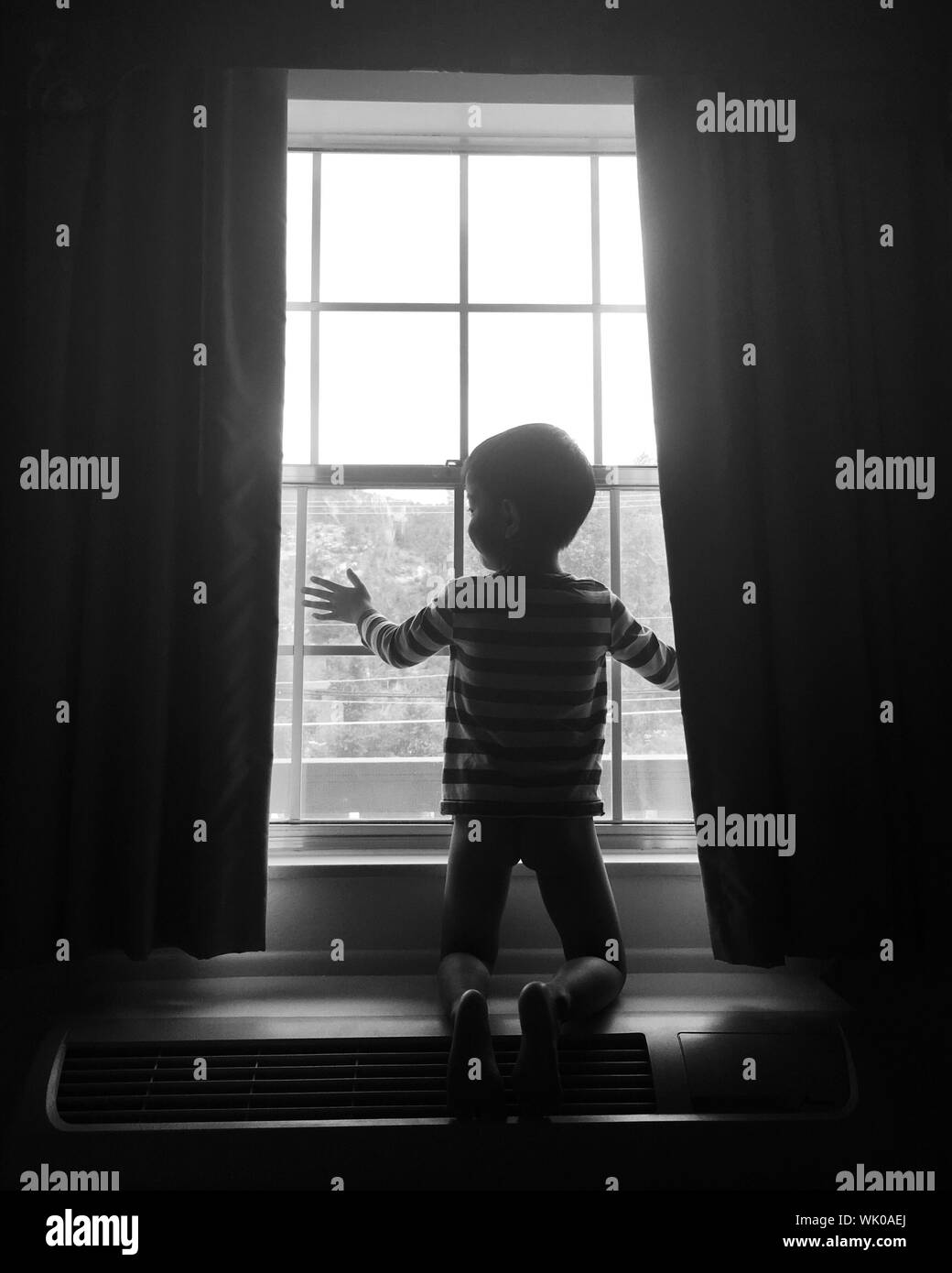 Boy looking in window Black and White Stock Photos & Images - Alamy
