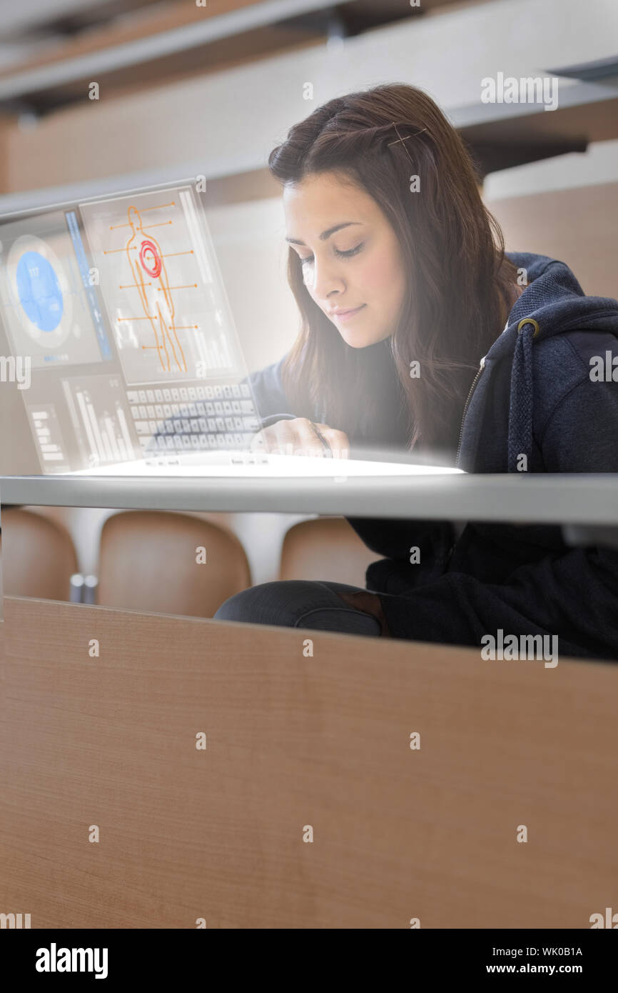 Girl sitting reading a book at the lecture hall Stock Photo - Alamy