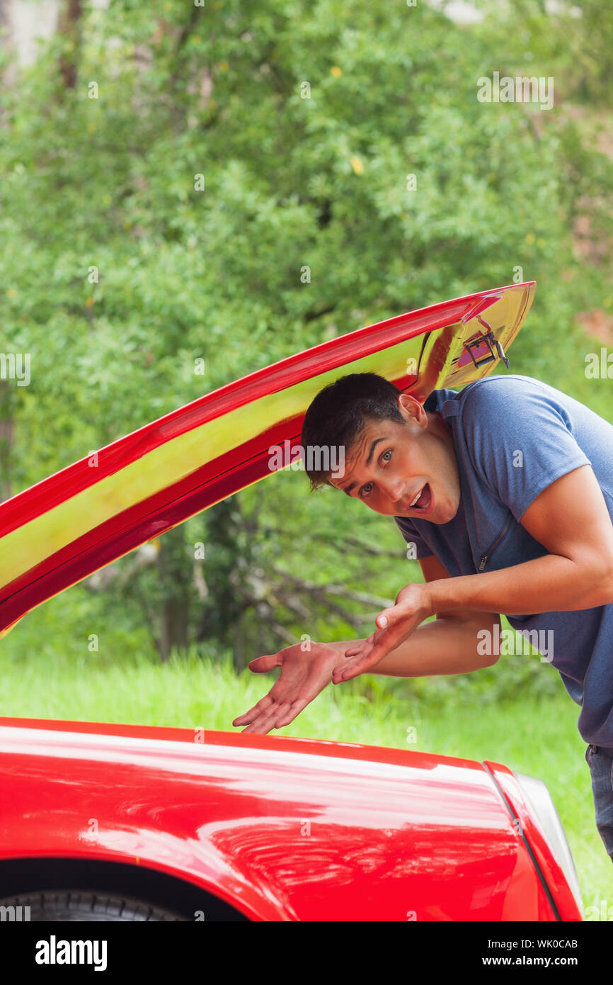 Lost young man checking his car engine after breaking down Stock Photo ...