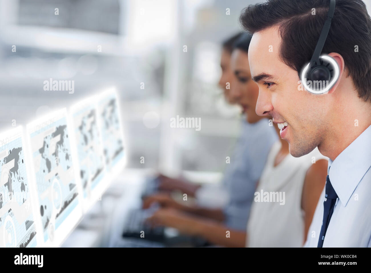 Focus on a smiling call centre agent working on computer Stock Photo ...