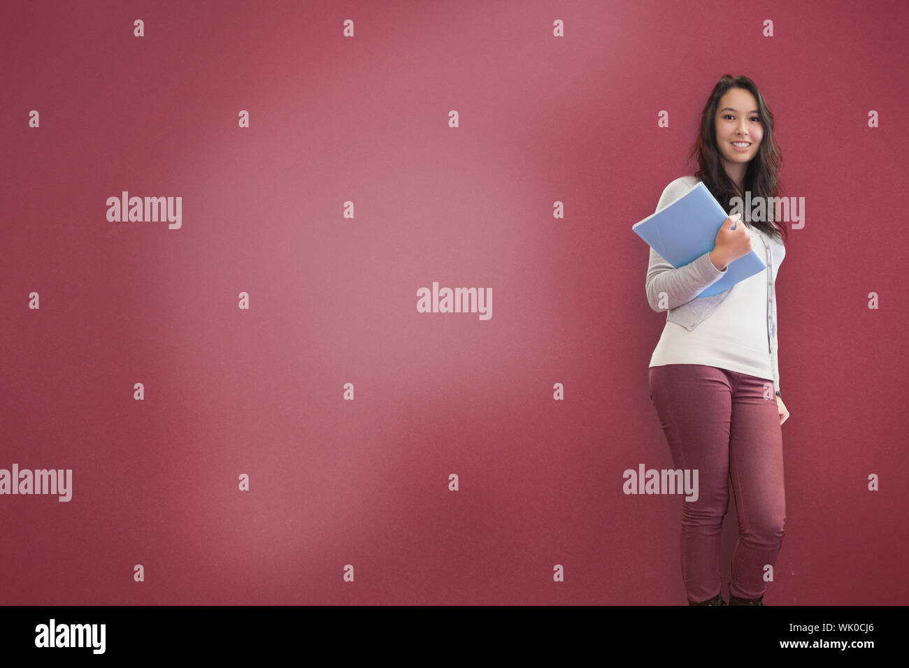 Cute brunette holding notebook posing Stock Photo - Alamy