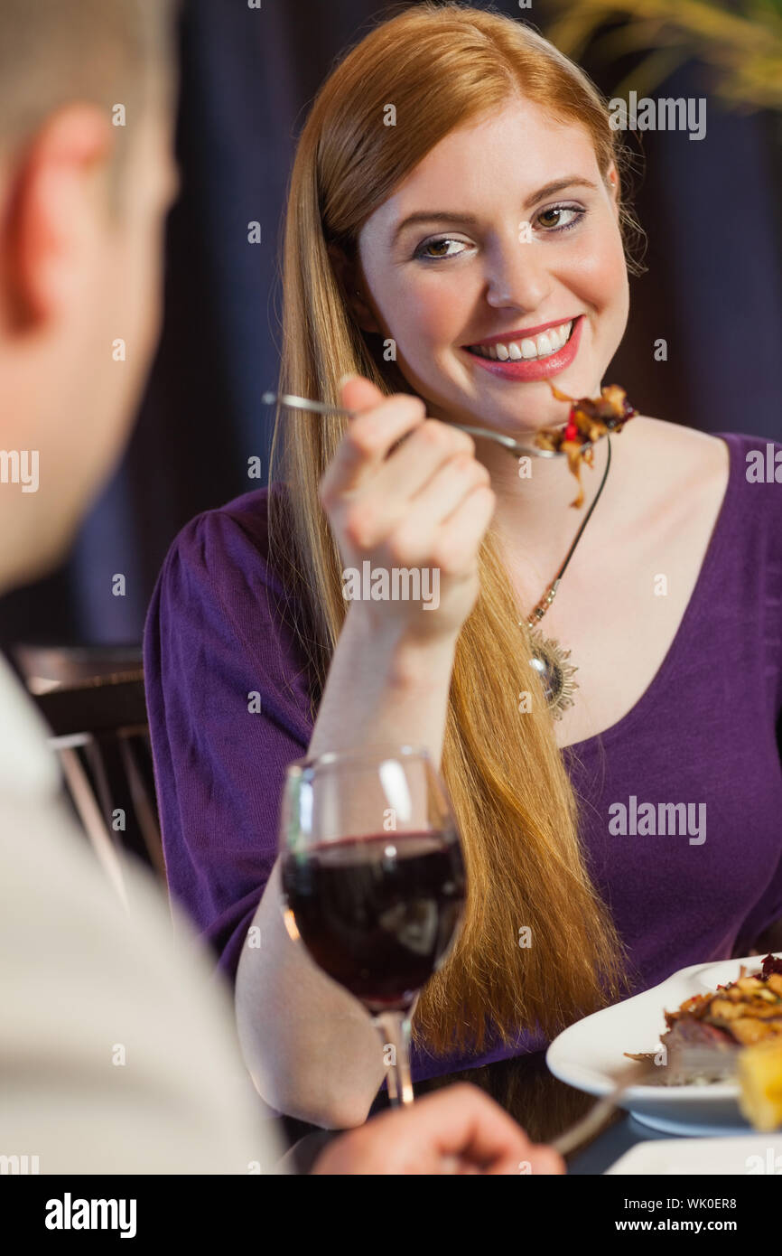 Pretty woman smiling at her husband during dinner Stock Photo - Alamy